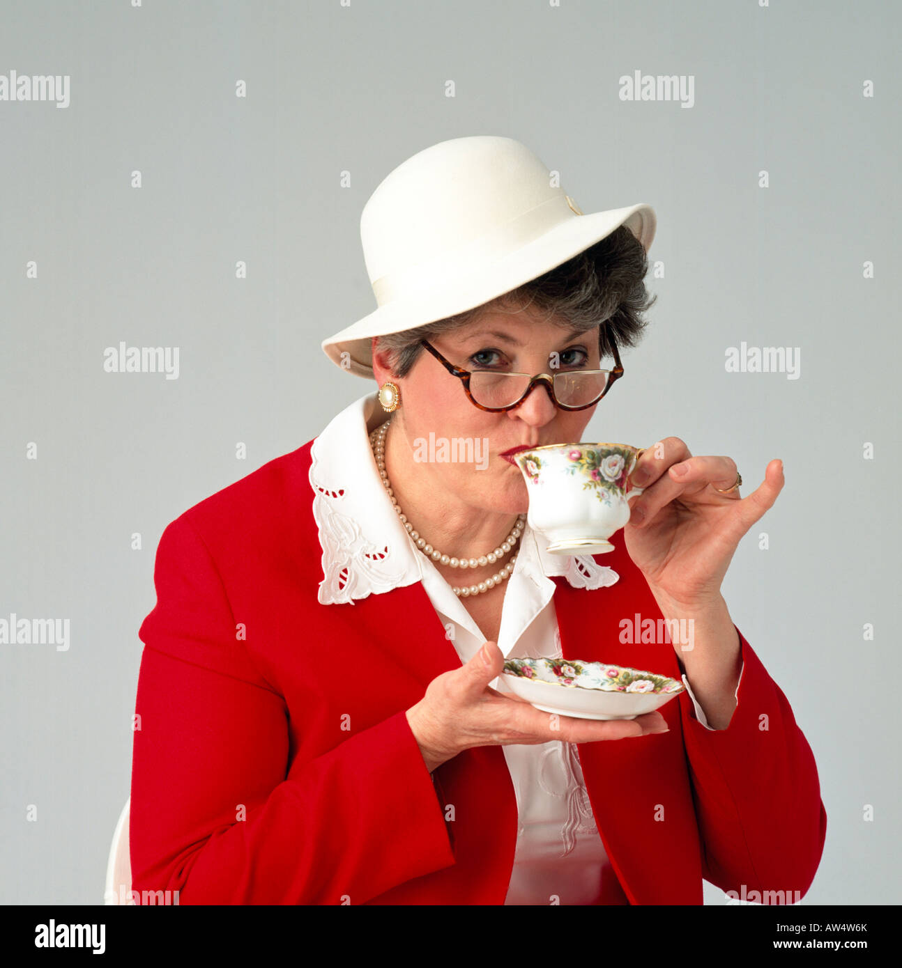 Woman sipping tea from a teacup Stock Photo - Alamy