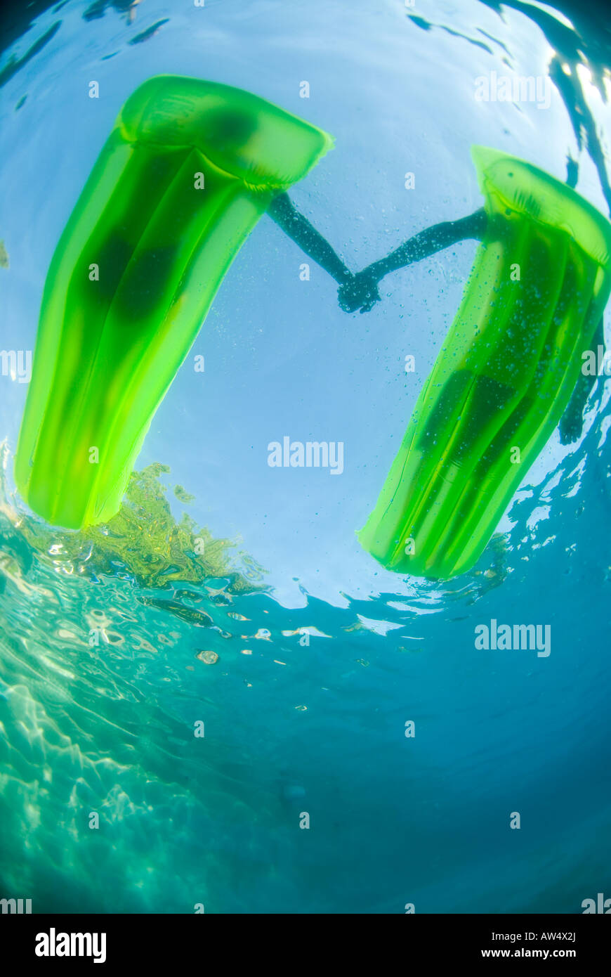Couple holding hands swimming underwater hi-res stock photography and ...