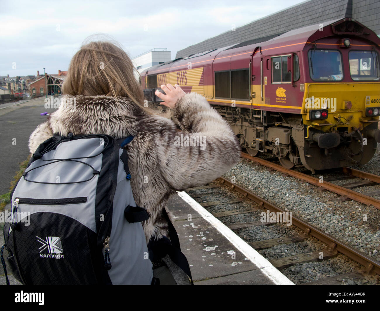 Woman trainspotter with mobile phone photographing a Class 66 ...