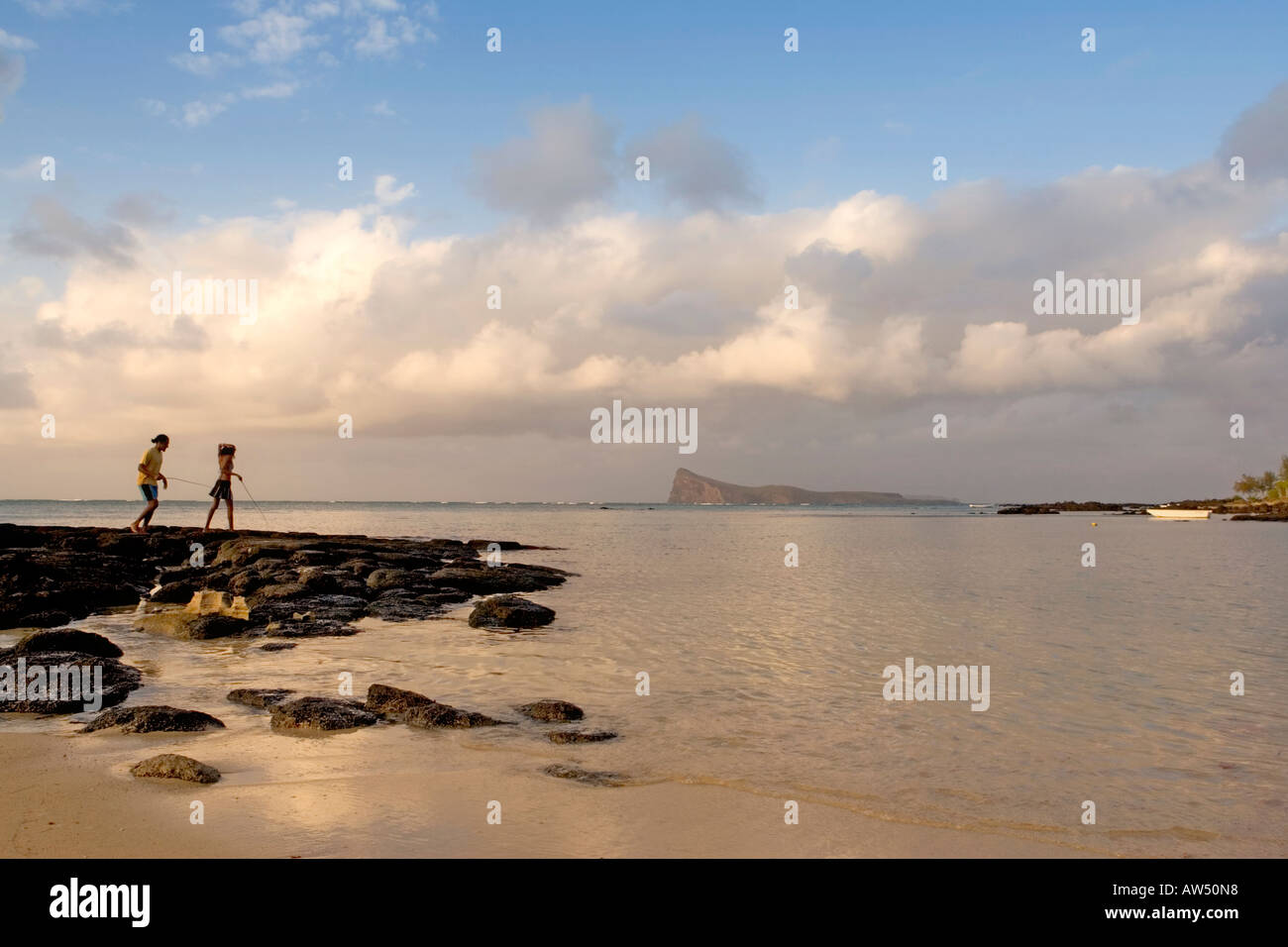 Couple walking on rocks at the beach in Northern Mauritius Stock Photo ...