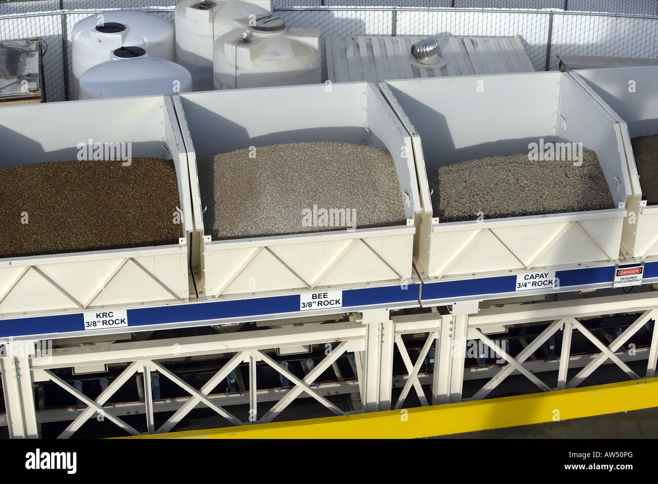 Bins of rock that drop onto a conveyer belt underneath and into the ...