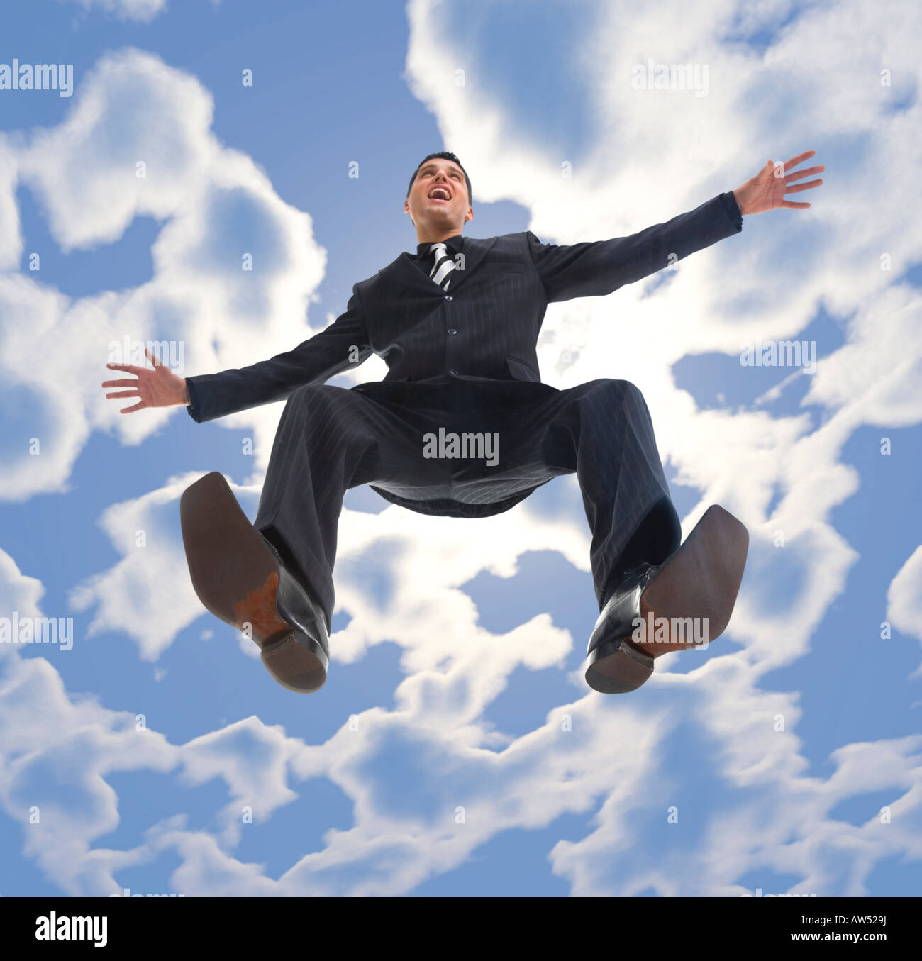 Young smiling businessman flying in the air he is looking at something ...