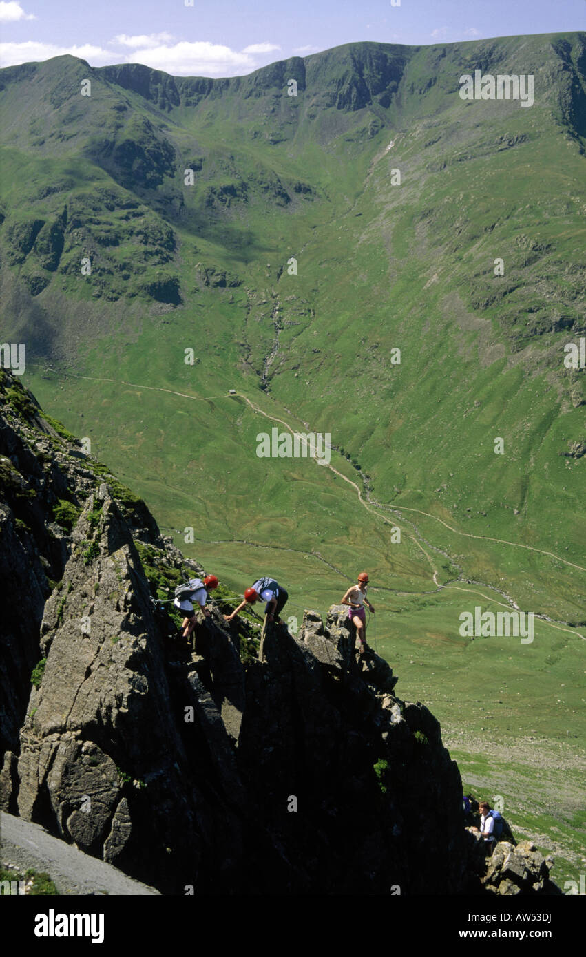 Four people in helmets climbing, Pinnacle Ridge, Lake district, England ...
