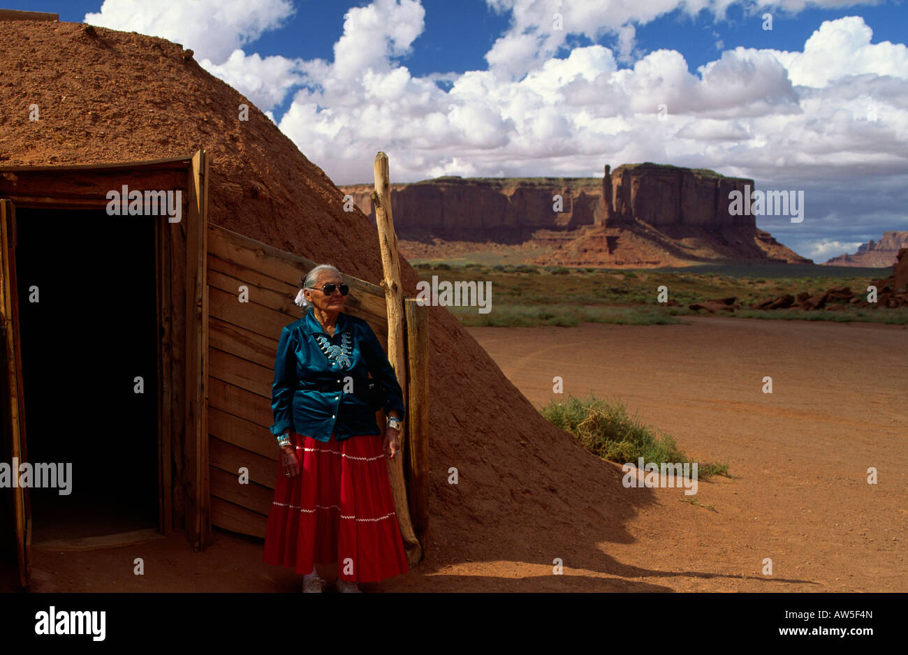 Navajo woman standing in front of traditional home called a Hogan in ...