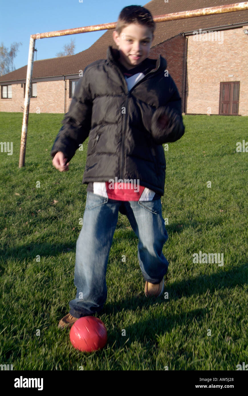 young kid child boy playing football soccer ball kick header heading ...