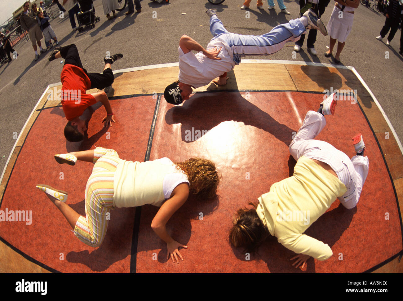Overhead of four male and female break dancers practising and ...