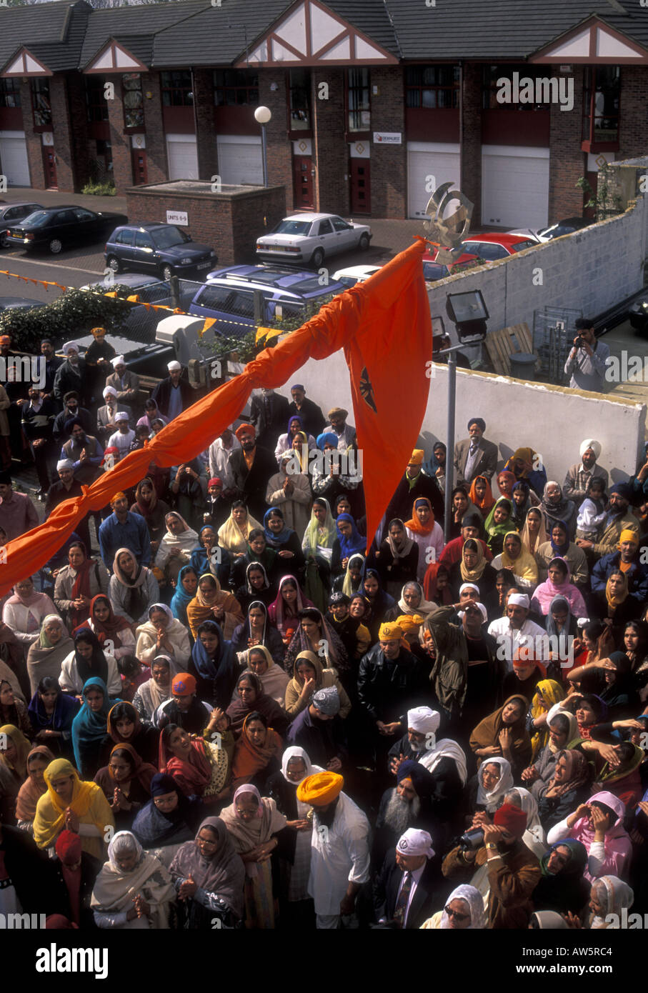 Sikhs watch the new flag or nishan sahib being raised at Baisakhi, New ...