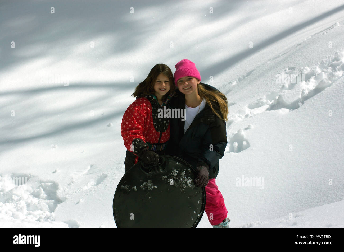 two girls with snow sled Stock Photo - Alamy