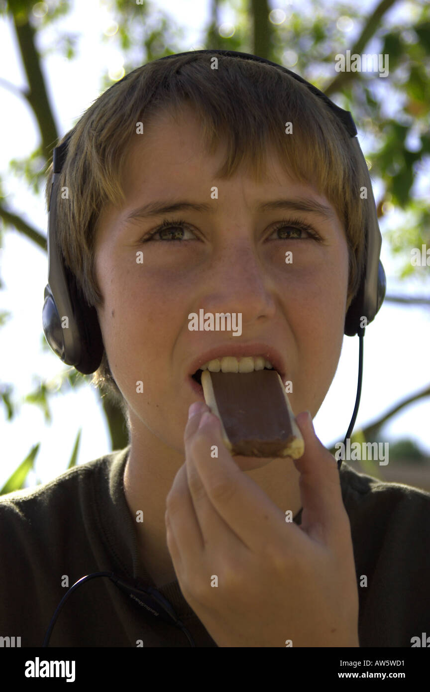 boy eating outside while listening to headphones Stock Photo - Alamy