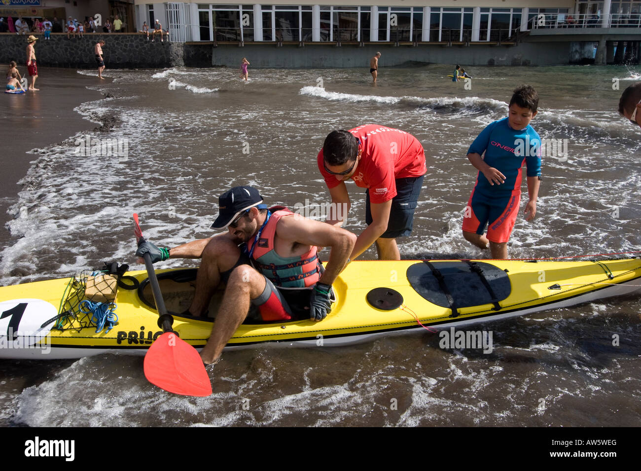 Exhausted canoeist struggling to get out of canoe after a 24hr canoe ...