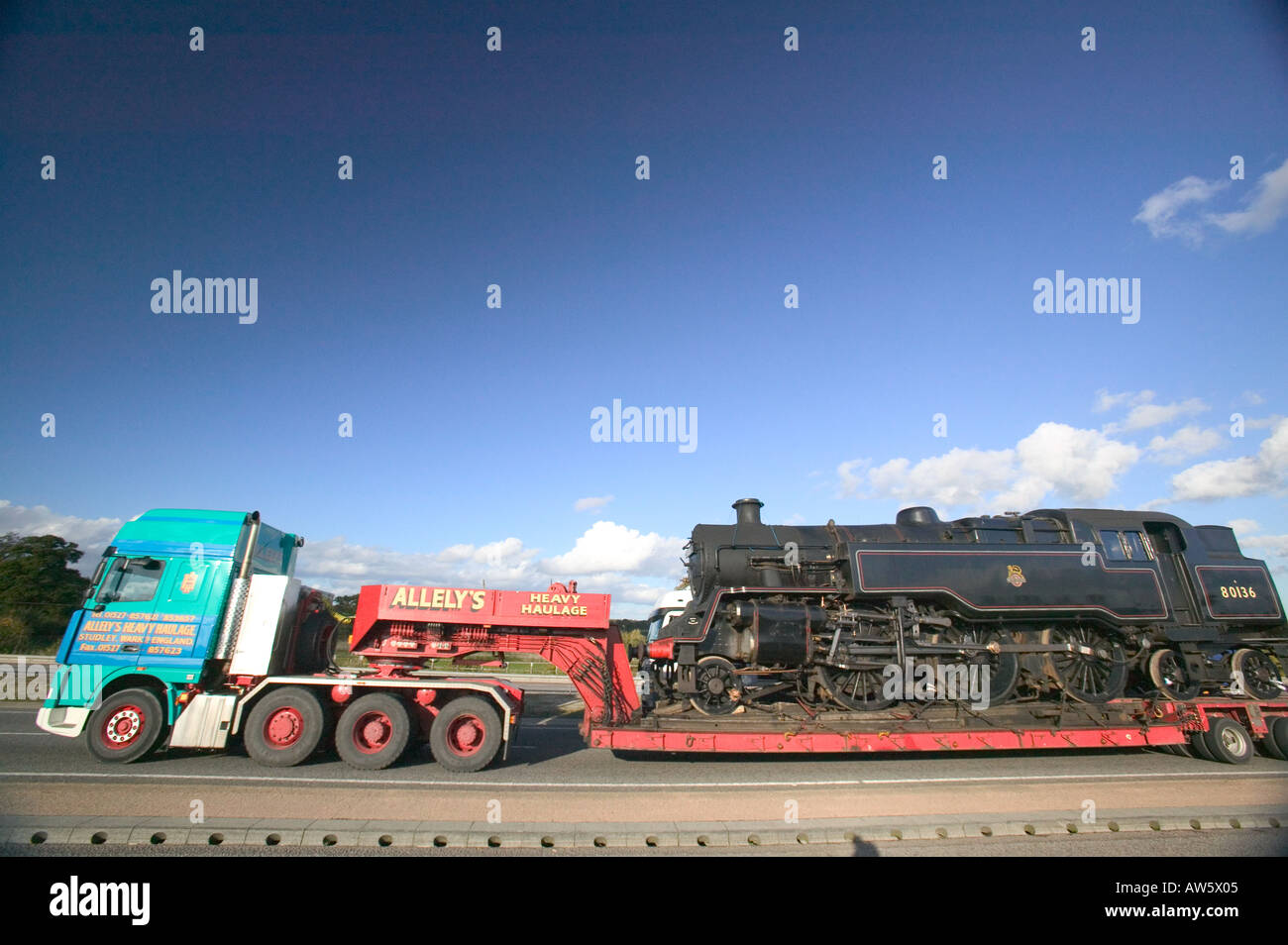Steam locomotive train being transported by road on a low loader ...