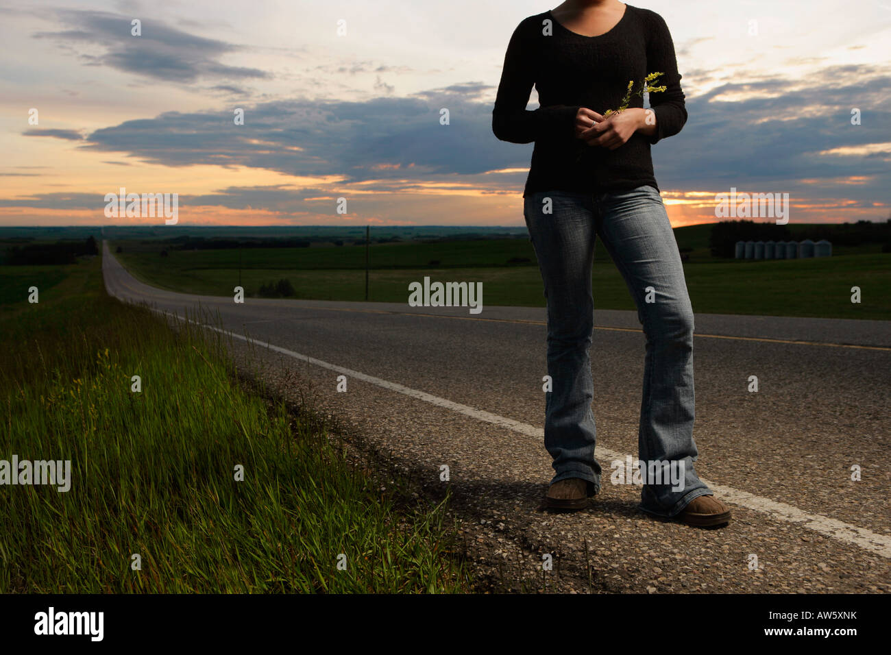 Woman standing at the side of the road Stock Photo - Alamy