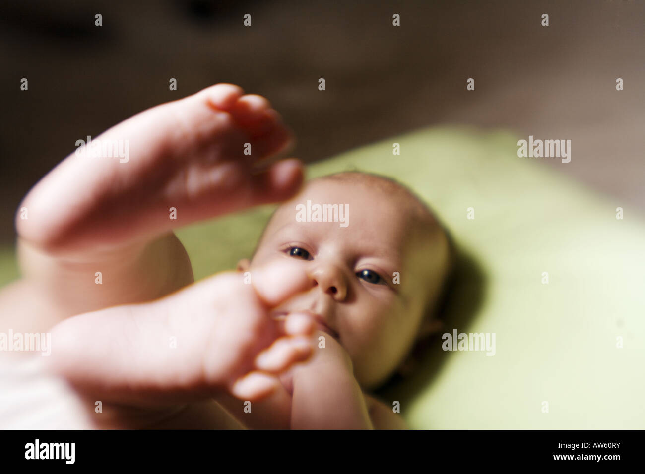 A silly baby discovers his feet for the first time Stock Photo - Alamy
