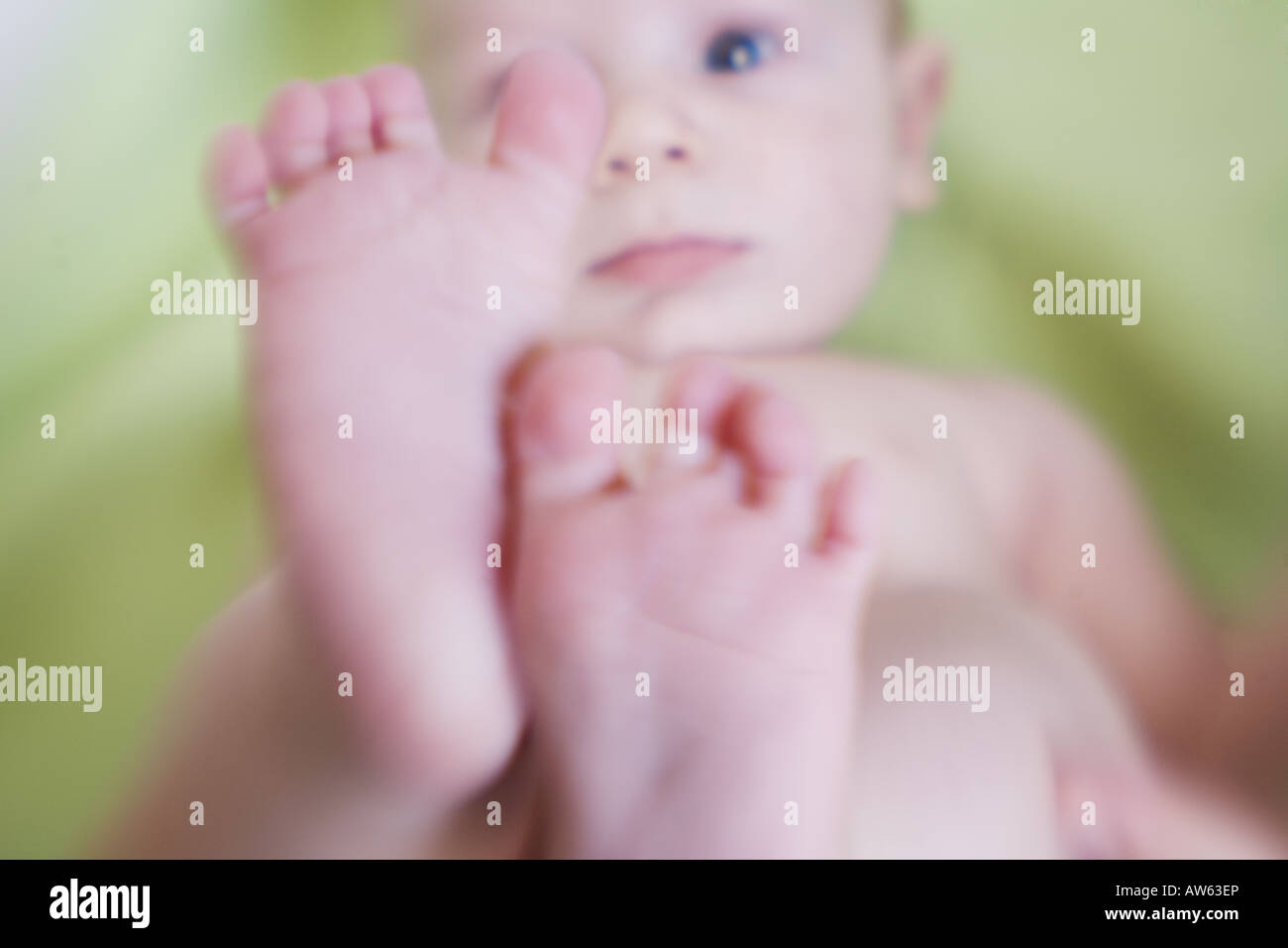 A silly baby discovers his feet for the first time Stock Photo - Alamy
