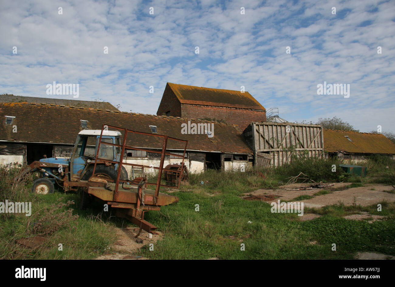 Tumbledown farm with old tractor and ramshackle buildings Stock Photo ...