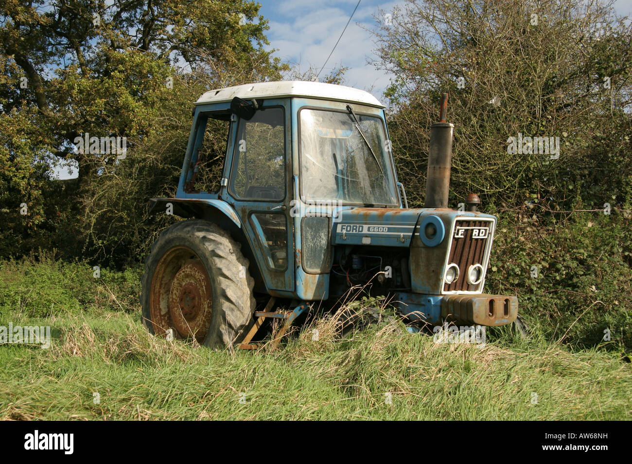 Old tractor in the corner of an unmowed field Stock Photo - Alamy