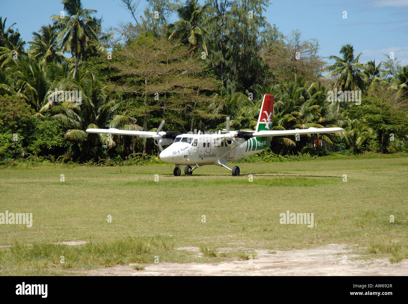 An Air Seychelles Twin Otter aircraft taxis on the grass landing strip ...