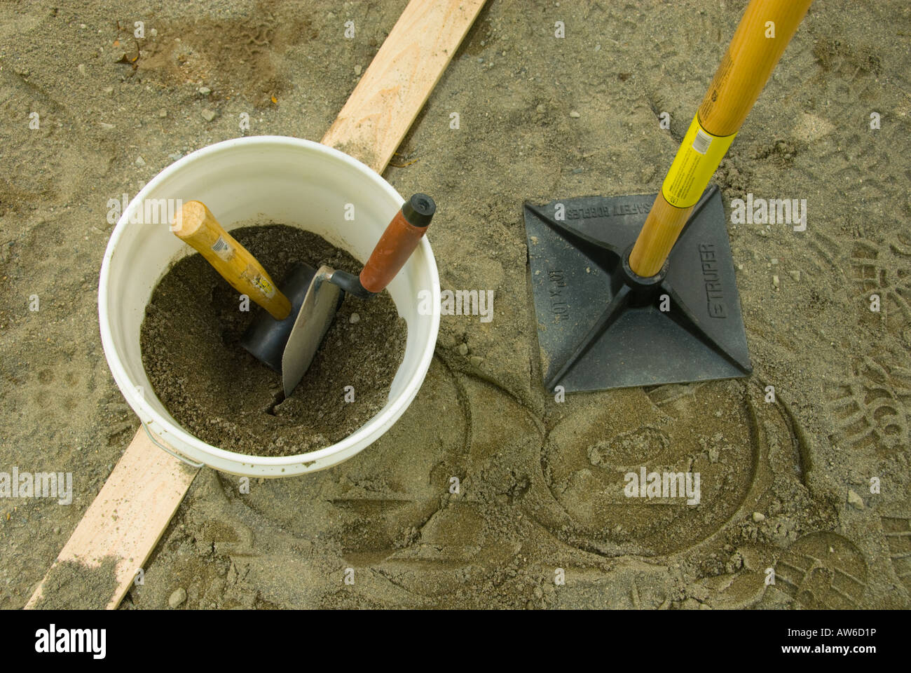 bucket with rubber hammer sand and spade stamper next to for brick ...