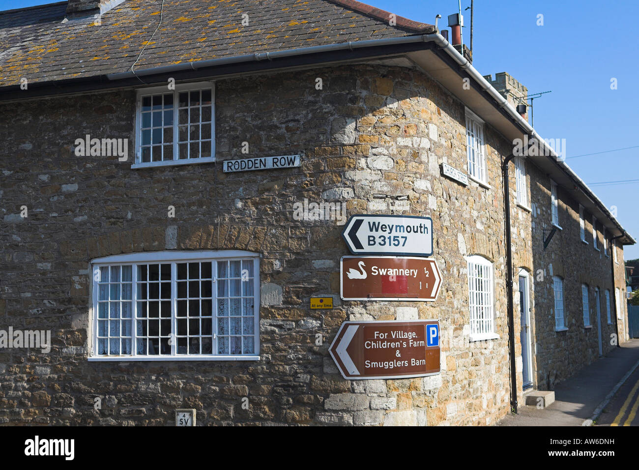 Road signs attached to traditional cottage, Abbotsbury, Dorset Stock ...