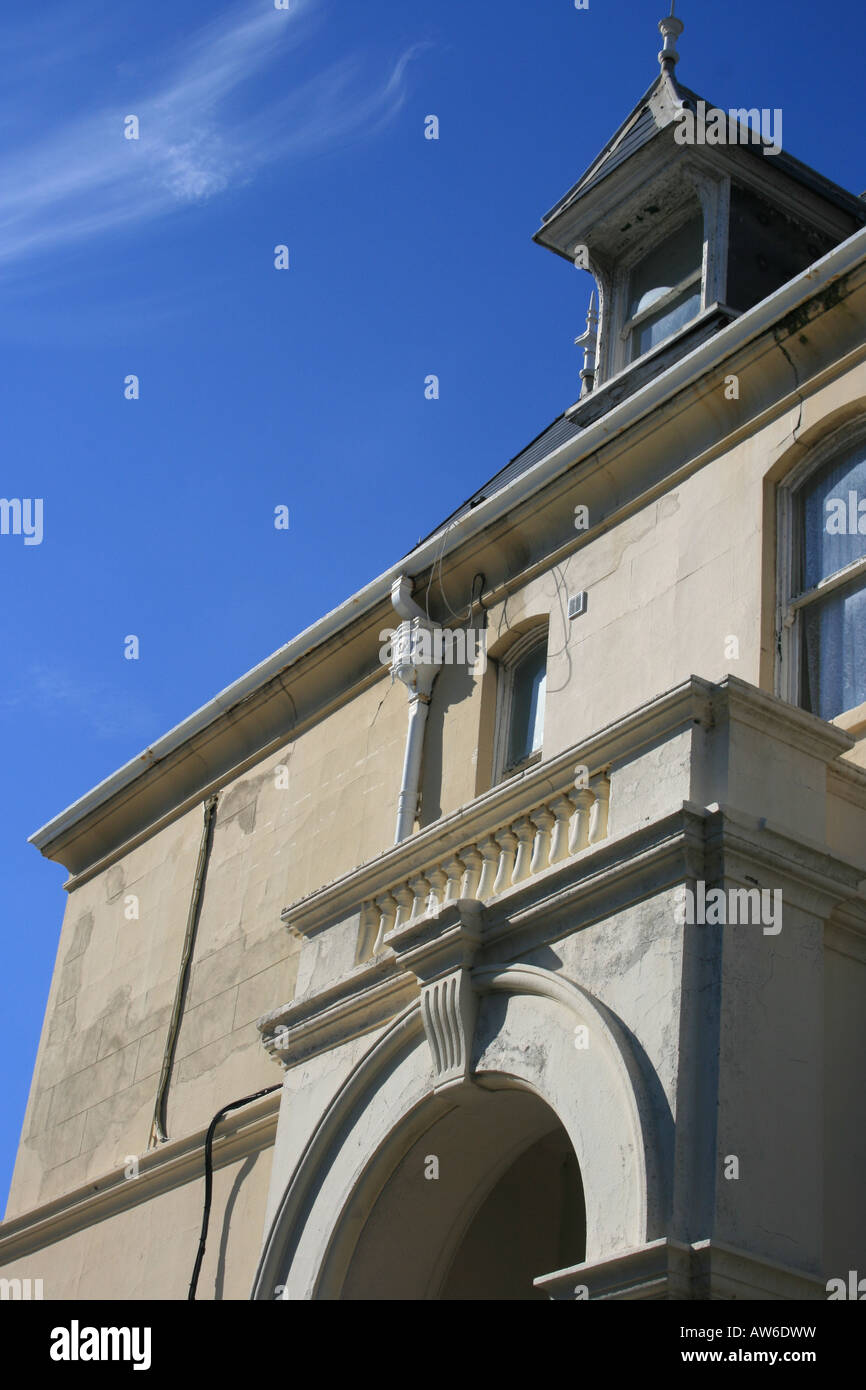 Stone coloured facade of a large house, looking upwards, against a ...