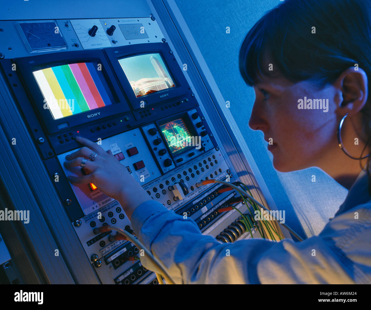 YOUNG WOMAN AT CONTROL PANEL WITH MONITORS IN LOCAL TV STUDIO UK Stock ...
