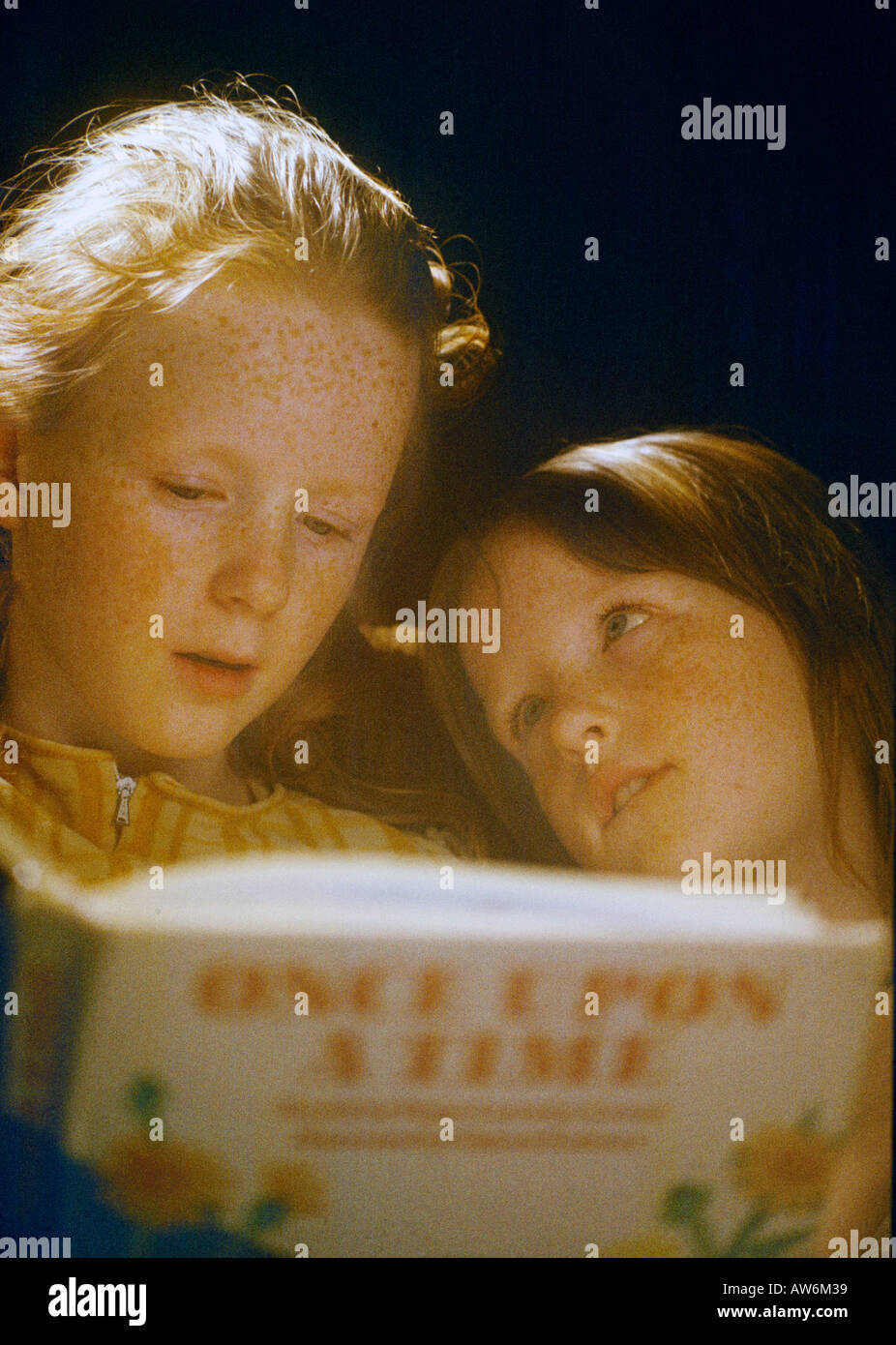 TWO LITTLE GIRLS (SISTERS) READING FAIRY TALE BOOK GRAIN AND SOFT FOCUS ...