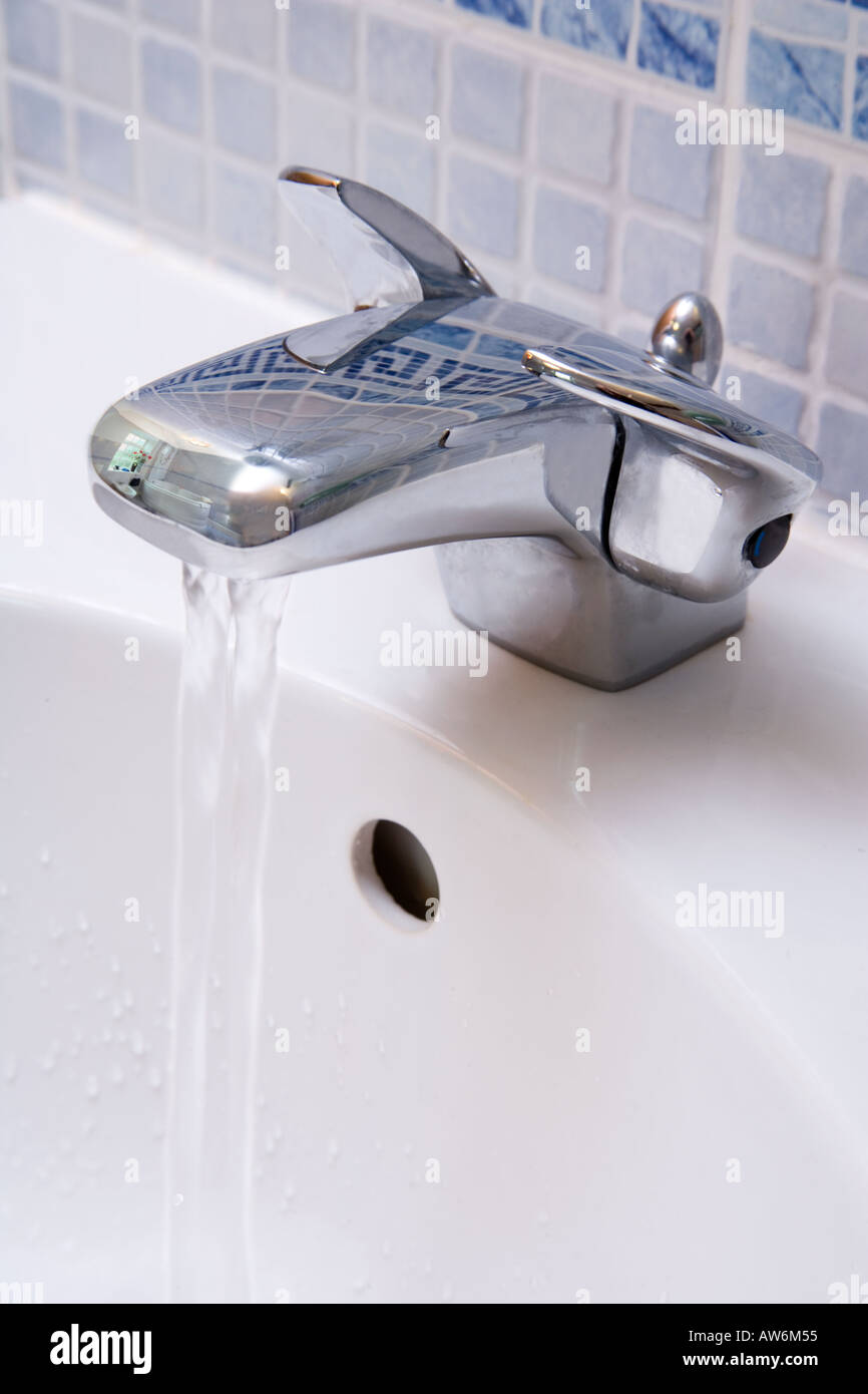 DUAL TAP RUNNING WATER IN SINK IN BATHROOM UK Stock Photo - Alamy