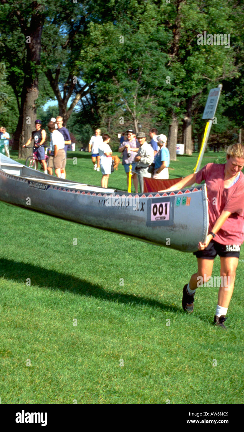 Women age 24 running with canoe to waters edge at Lake Nokomis. Courage ...