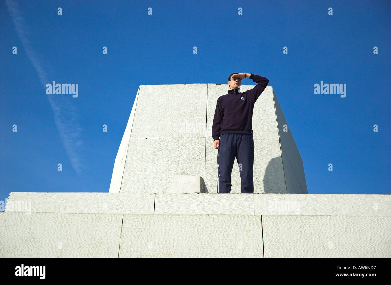 One young man standing on monument looking into distance Stock Photo ...
