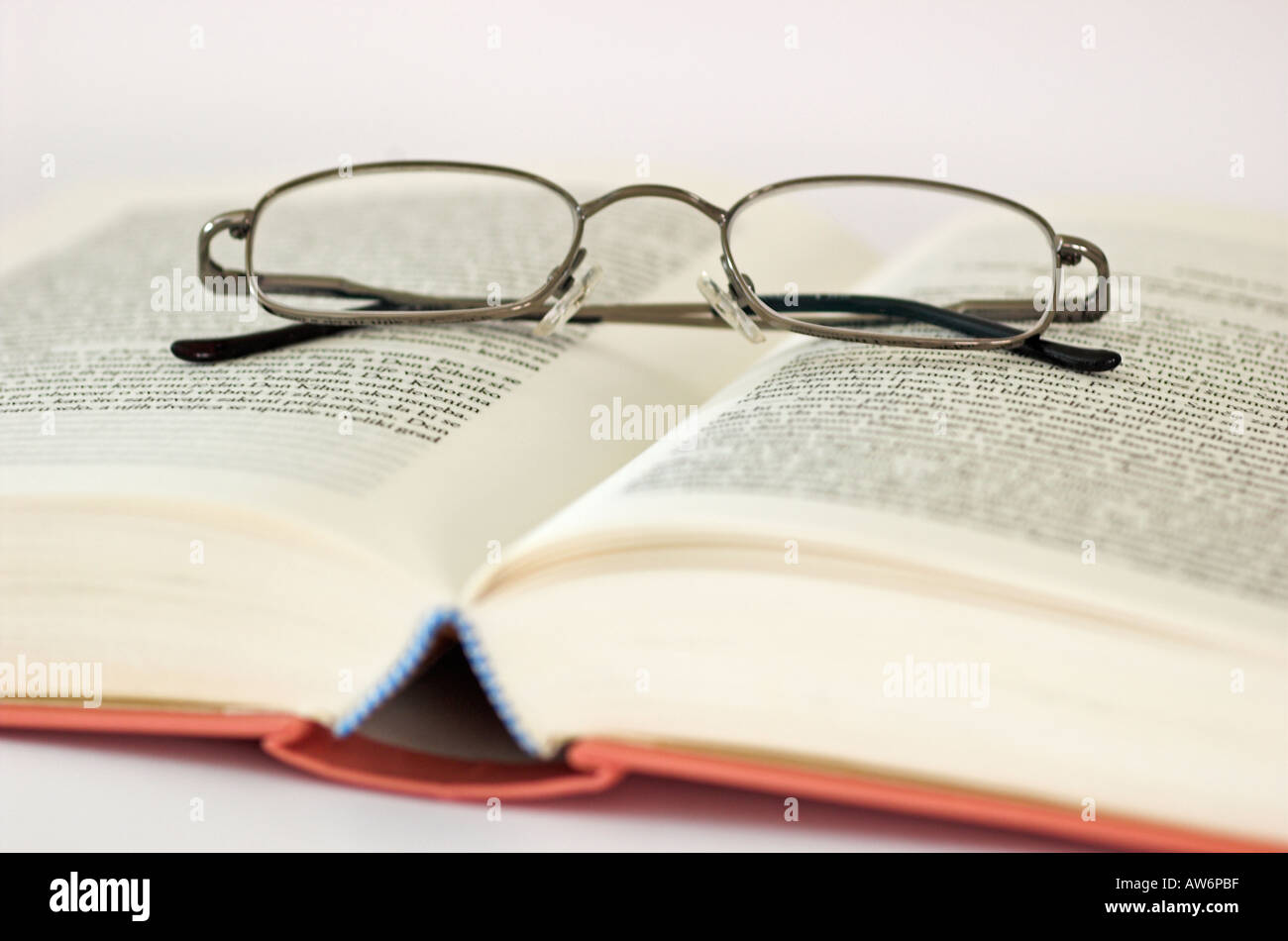 Open book with eyeglasses on top Stock Photo - Alamy