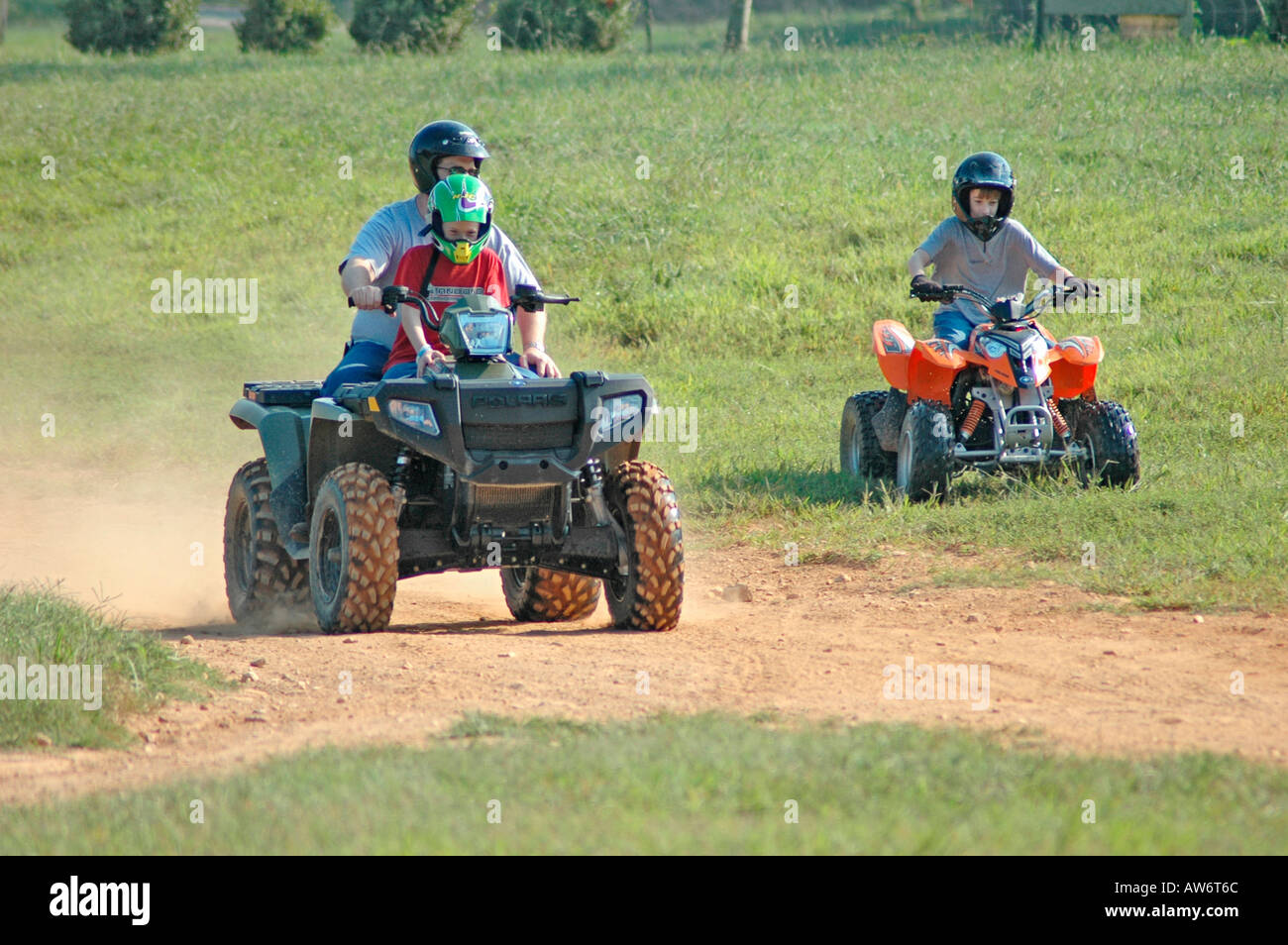 Father and real Son on 4 wheeler on dirt road during learning session ...