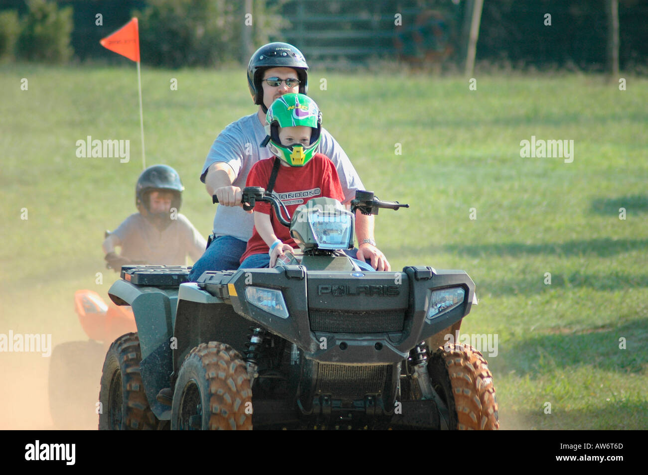 Father and real Son on 4 wheeler on dirt road during learning session ...