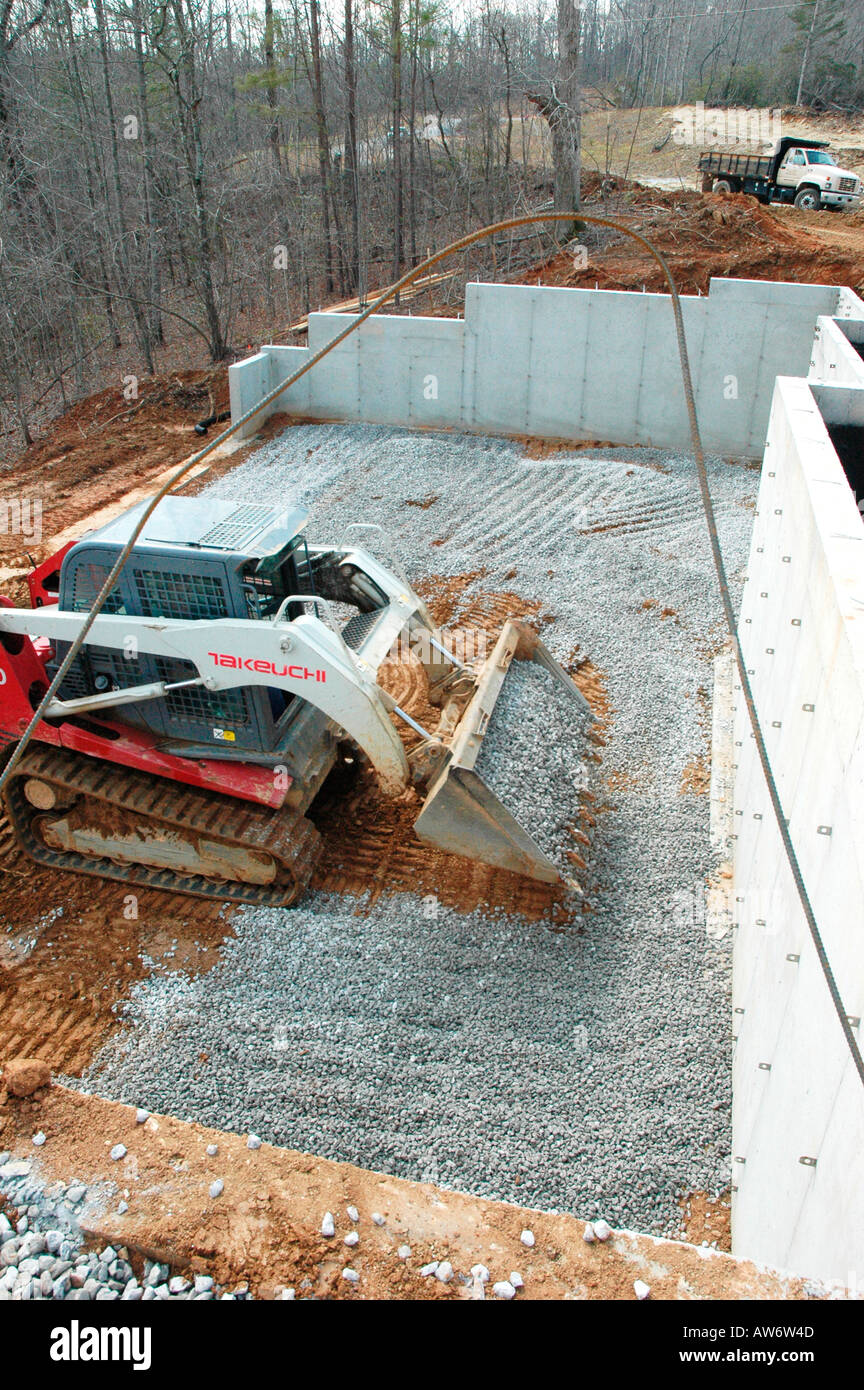 Bobcat working on new home construction on the floor of the basement ...