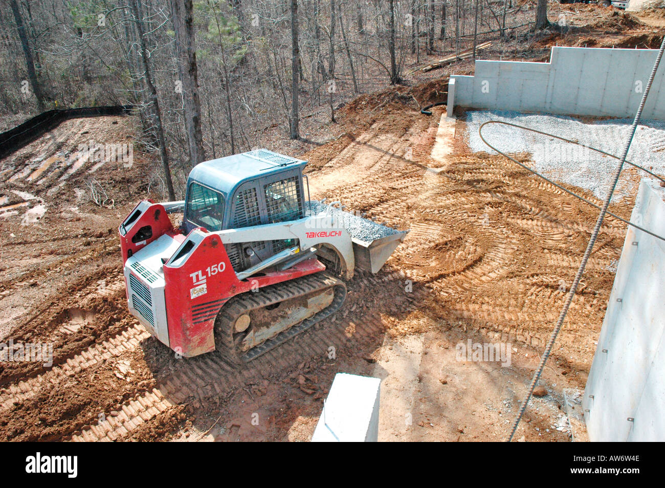Bobcat working on new home construction on the floor of the basement ...