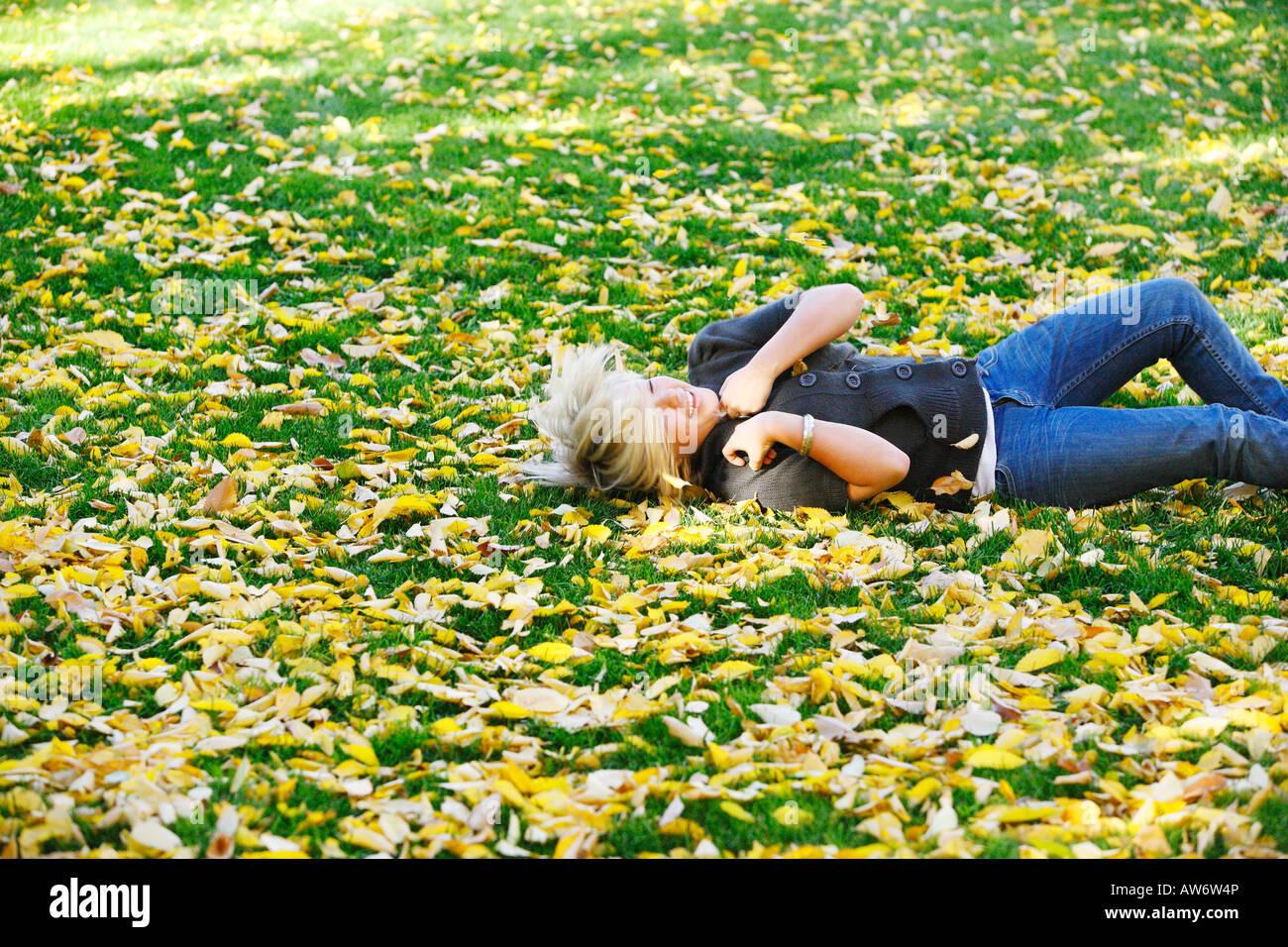 Teenage girl rolling down a hill Stock Photo - Alamy