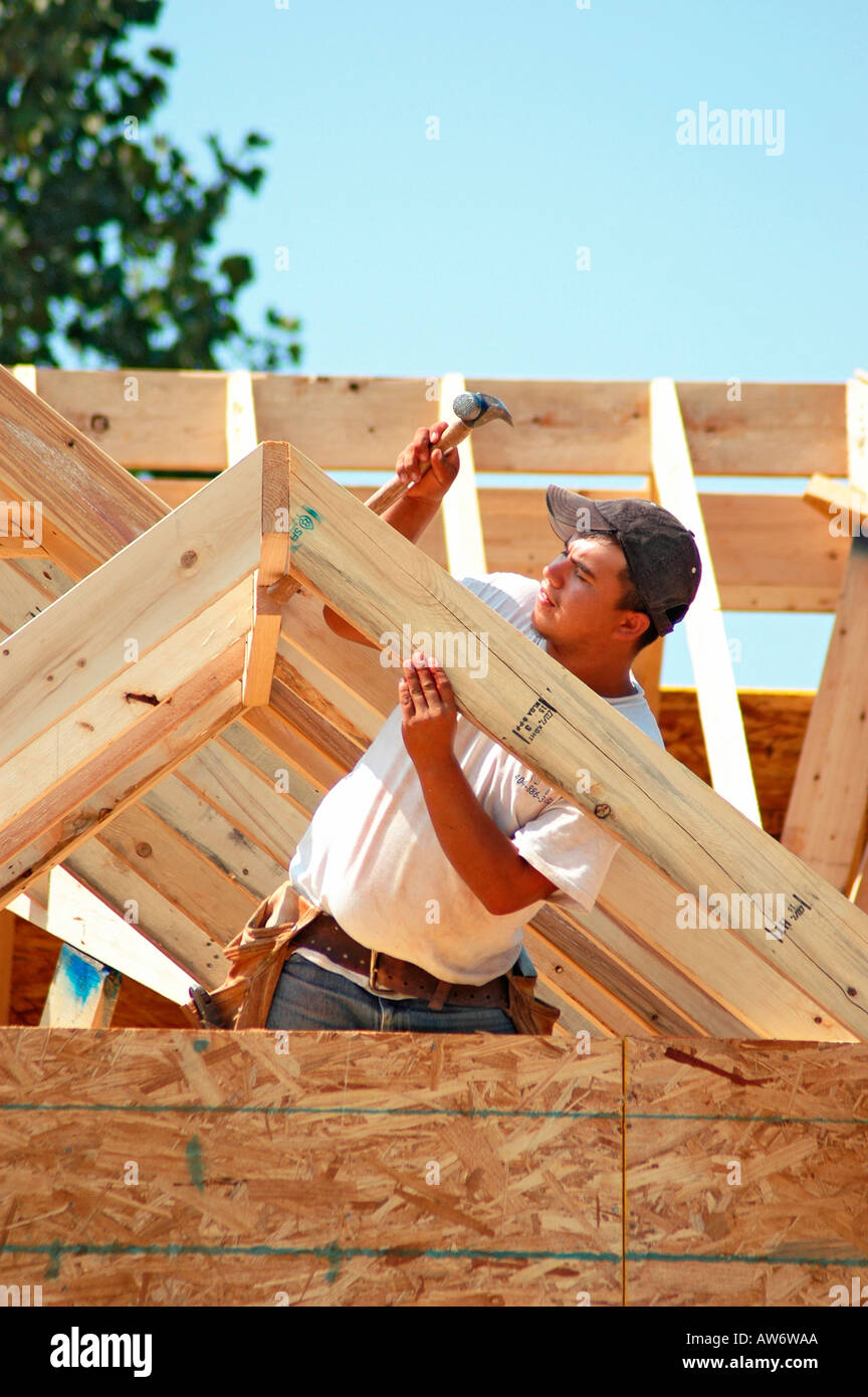 Roofers putting on sub roof of partical board on new home construction ...