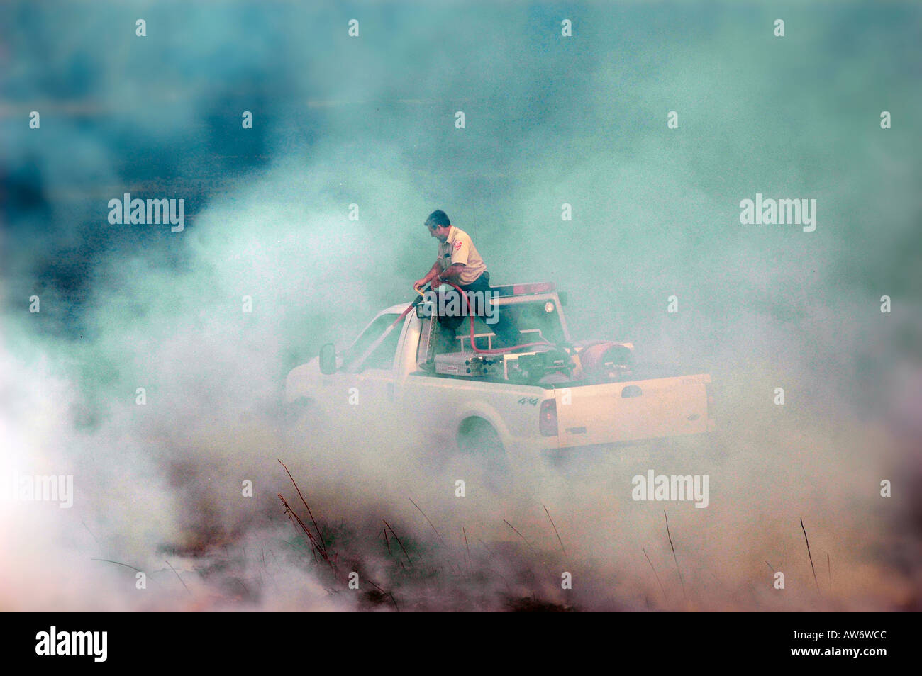 Firemen fighting a brush fire in the Atlanta area with water and safety ...