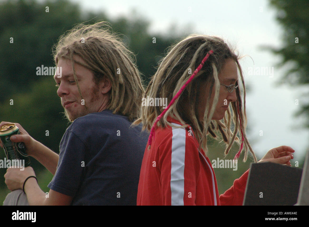 caucasian couple, both with dreadlocks sitting back to back Stock Photo ...
