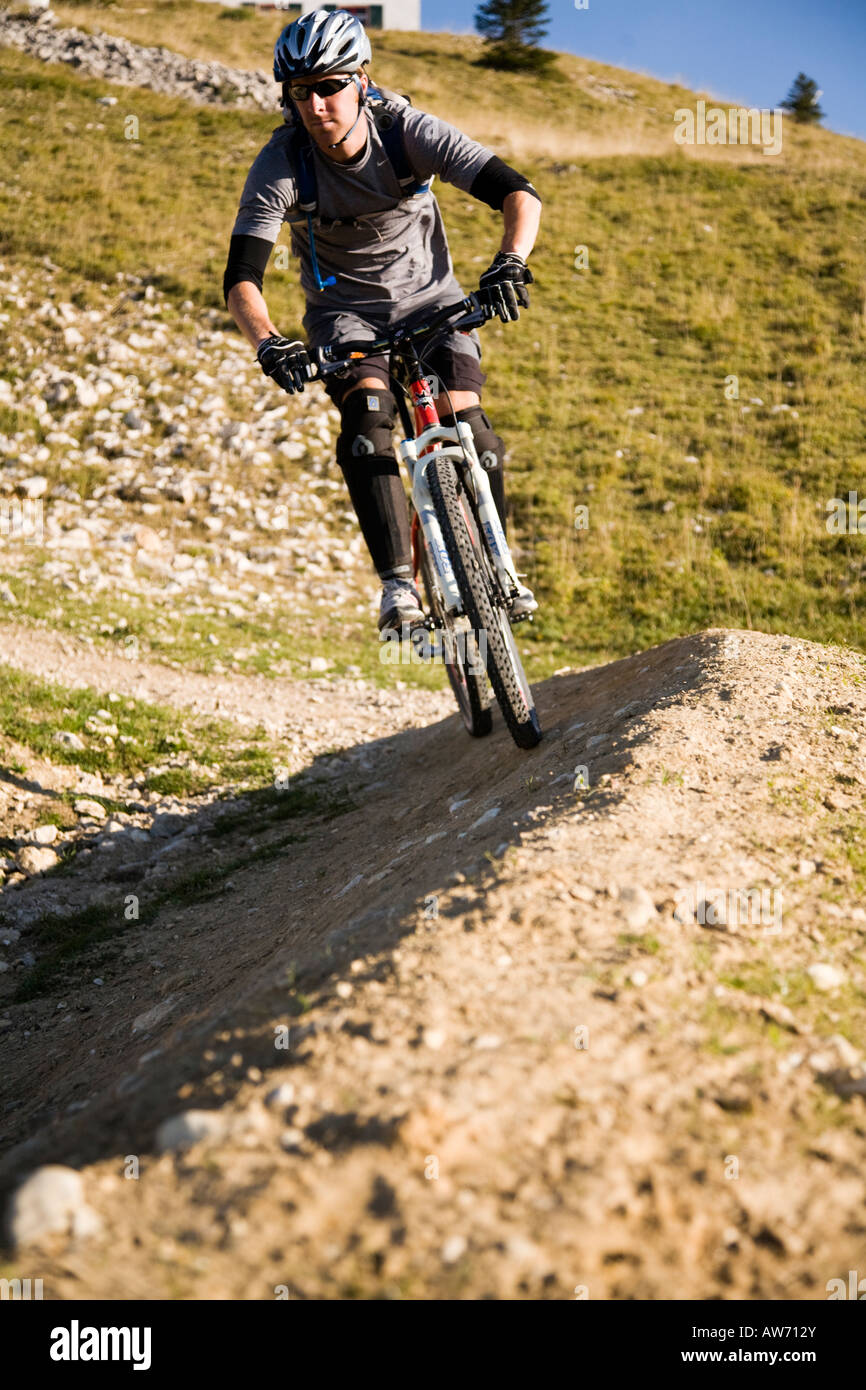man riding mountain bike down a berm cote 2000 ski slope villard de ...