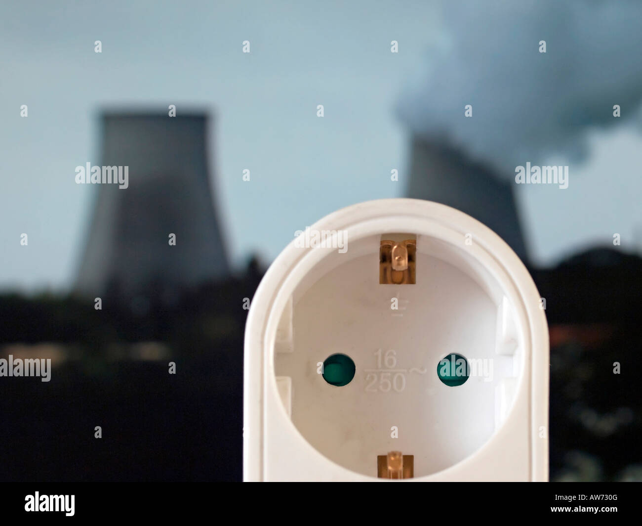 socket with a power plant with steaming cooling tower in the background ...