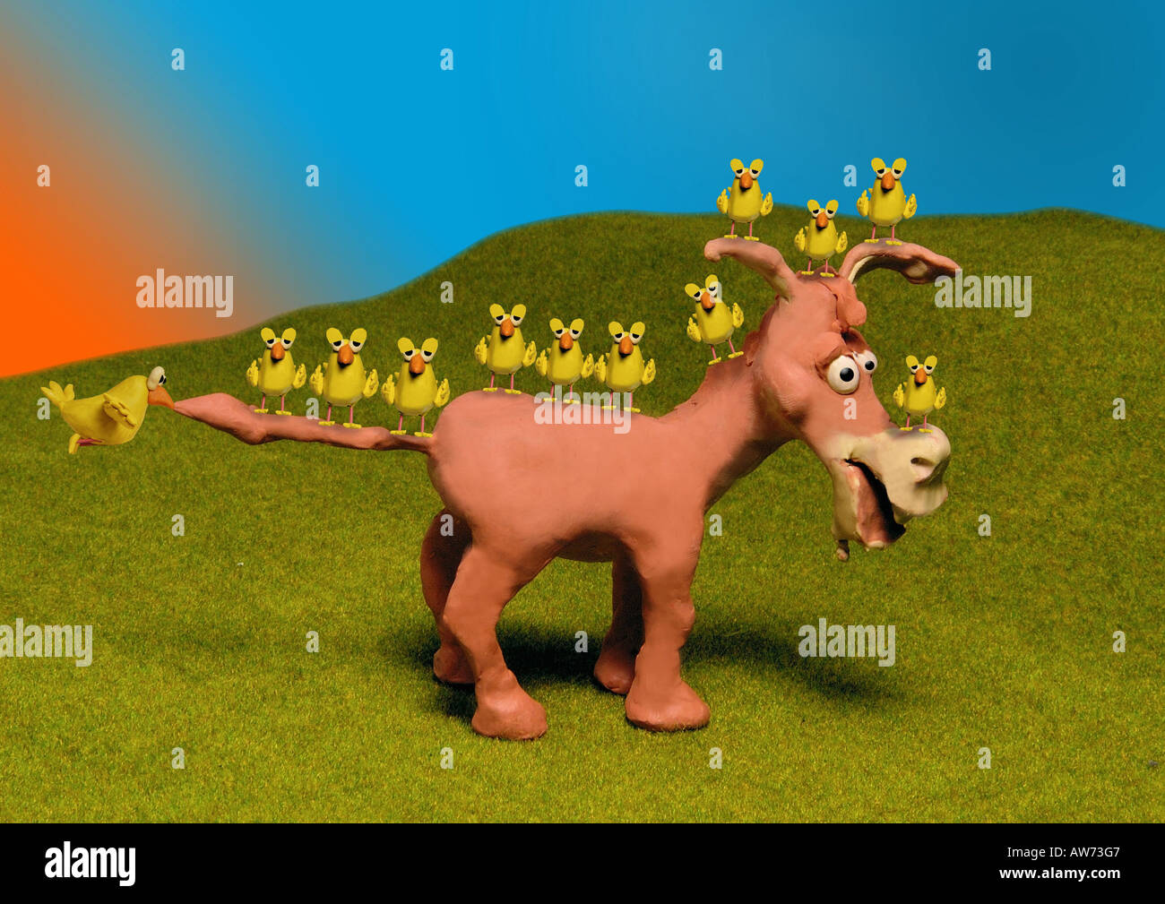 Donkey in the field with yellow birds lined up on him Stock Photo - Alamy