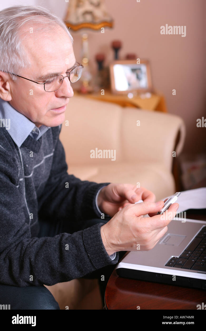 Senior man using a memory stick and a laptop Stock Photo - Alamy
