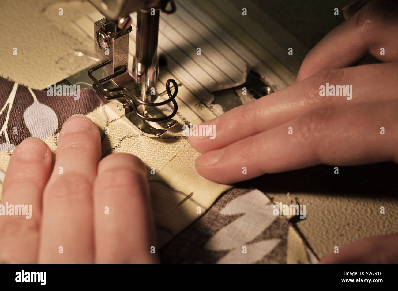 Hands near a sewing machine foot in motion Stock Photo - Alamy