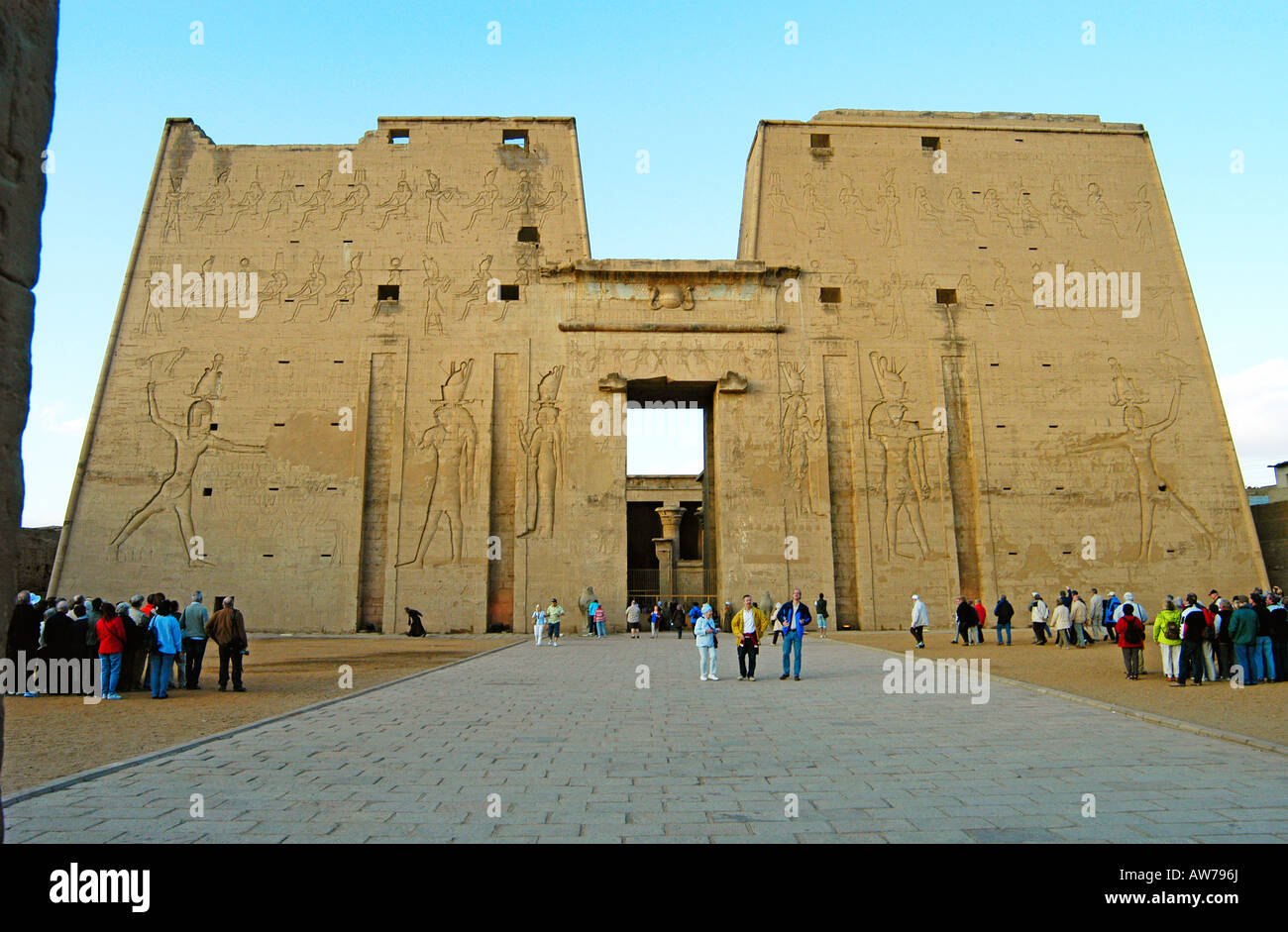 Tourists admire the exterior of the Ptolemaic Temple of Horus, Edfu ...