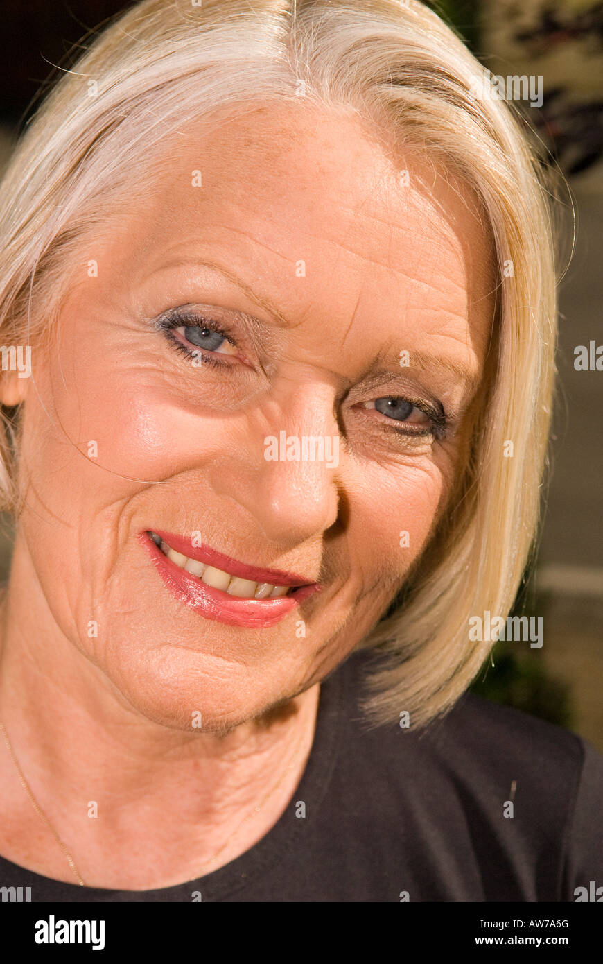A beautiful older model posing in the sunshine and smiling Stock Photo ...