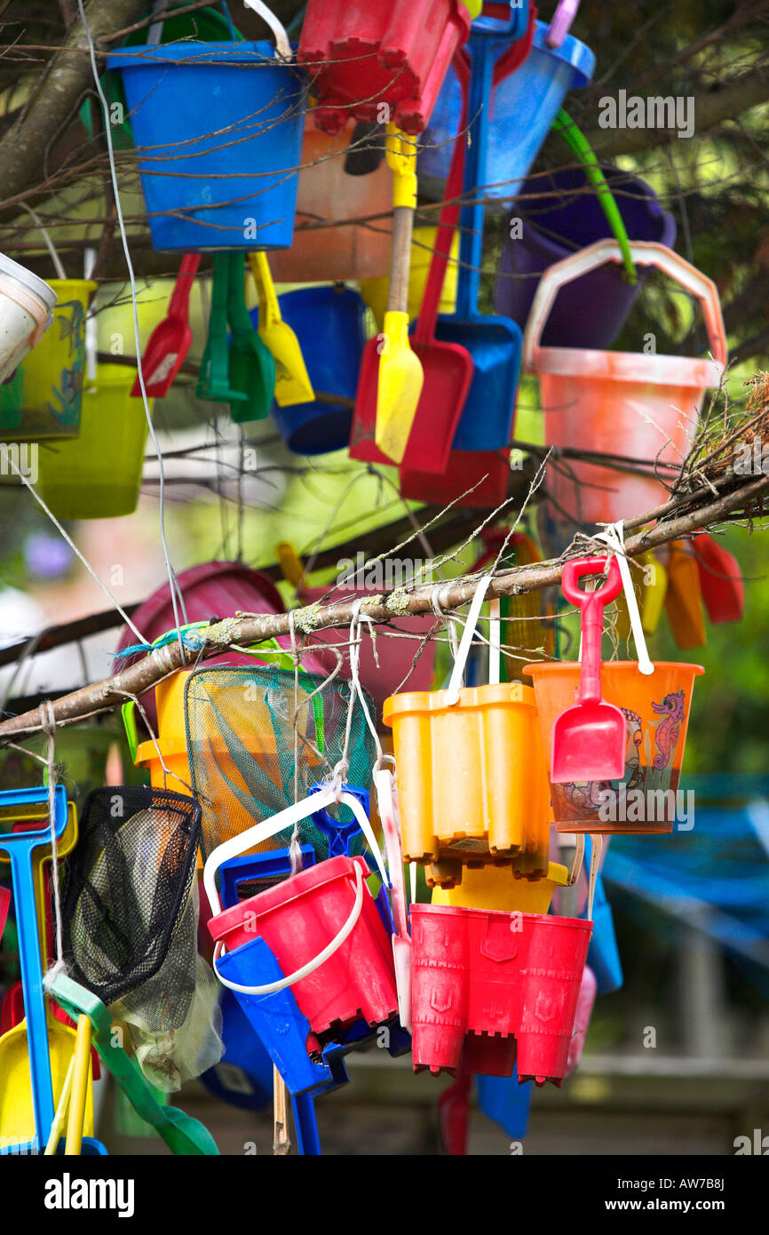 Lost and abandoned buckets and spades hung from a tree, Lulworth ...