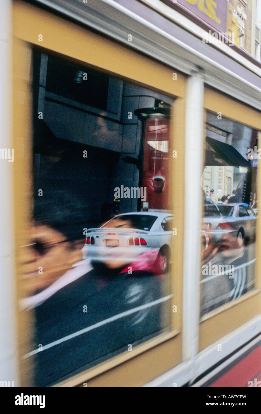 Passengers and traffic merge on a cable car window in San Francisco ...