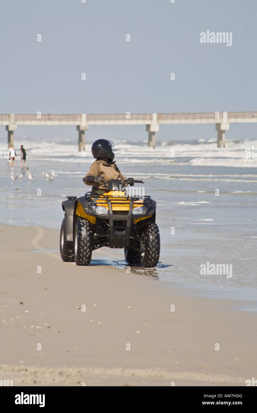A police officer patrols the beach on an ATV close to Jacksonville ...