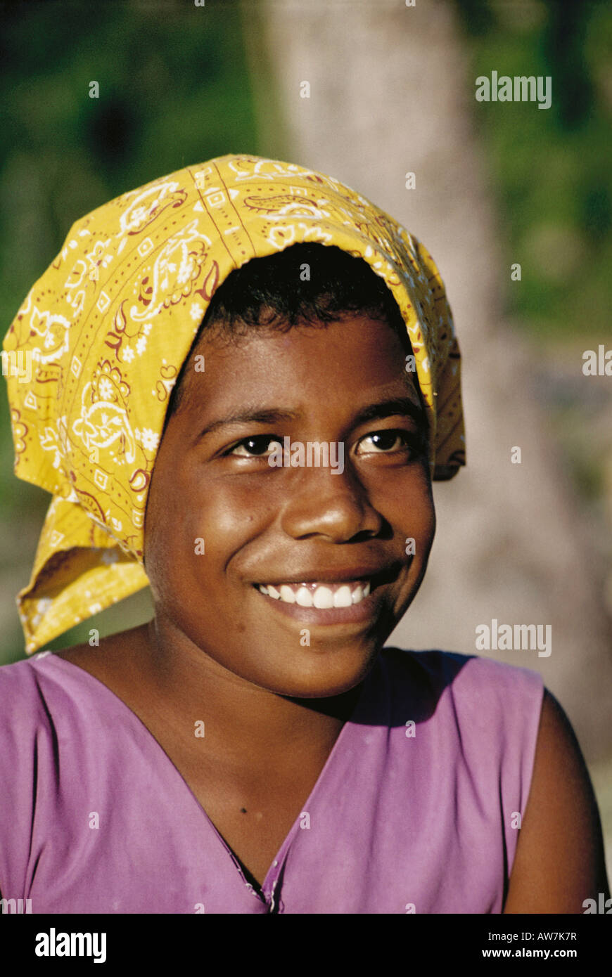 A 12 year old girl in Fiji smiles broadly as she wears a new kerchief ...