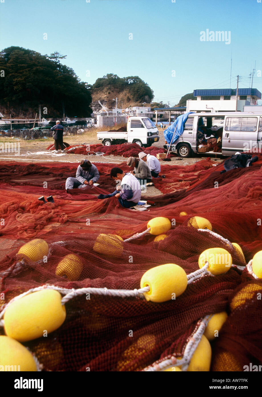 Fishermen repairing their fishing nets Stock Photo - Alamy